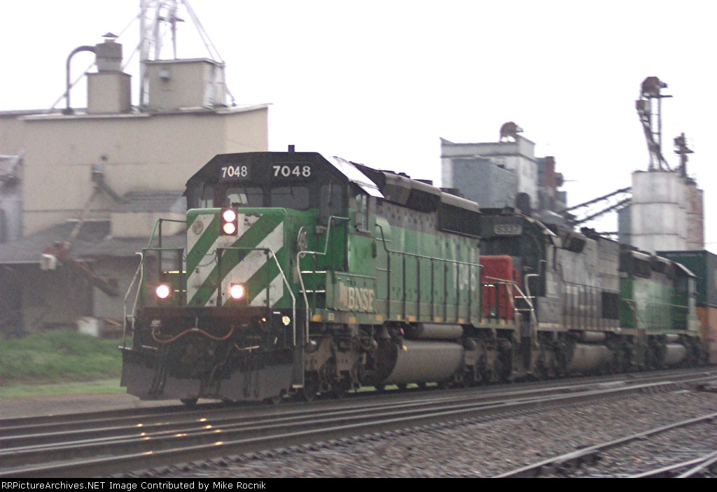 BNSF 7048 sprints through the Xovers at Wadena in a lite rainfall